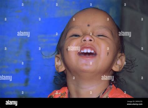 Cute Baby Girl Making Smiley Face With Blue Background Stock Photo Alamy