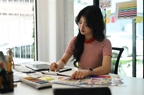 컬러 팔레트로 작업하는 젊은 창조적인 여성 그래픽 스튜디오에서 디자인 프로젝트를 위한 색상 샘플을 선택합니다 20 24세에 대한