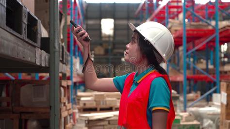 4k Asian Woman Staff With Safety Hard Helmet And Uniform Checking Storage Stack Box Parcels In
