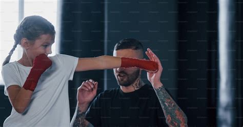 기본 펀치 젊은 문신을 한 권투 코치는 체육관에서 귀여운 소녀를 가르칩니다 사진 Unsplash의 운동 이미지