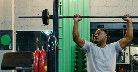 휠체어를 탄 남자가 체육관에서 바를 들어 올린다 사진 Unsplash의 운동 이미지