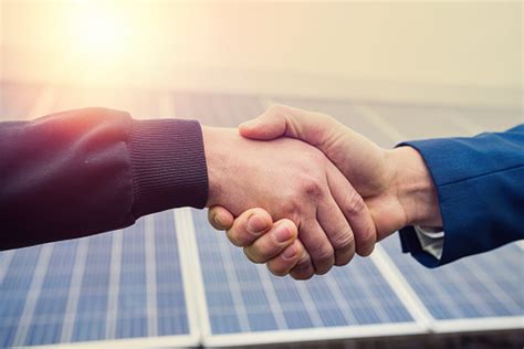 작업복과 헬멧을 착용한 두 명의 작업자가 패널 계획을 완료한 후 악수를 합니다 동업에 대한 스톡 사진 및 기타 이미지 동업