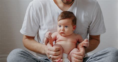 무릎을 꿇고 신생아를 안고 있는 행복한 백인 아버지 흔들리는 아이 딸 아들을 껴안고 있는 남자 부모 본격적인 라이프 스타일 솔직한 순간 자랑스러운 젊은 아빠 가족