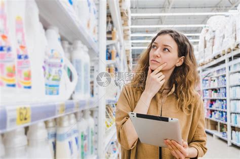 女商人正考虑在超市用一块牌子买东西呢高清图片下载 正版图片505252933 摄图网