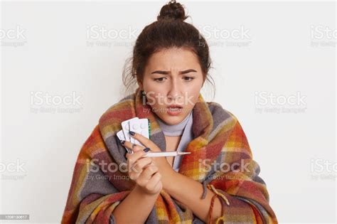 건강에 해로운 예쁜 여자는 알약과 Termomether를 보유하고 약을 복용 온도를 낮추려고 나쁜 감기 또는 코로나 바이러스에서 치료 흰색 배경 위에 고립 된 포즈 건강