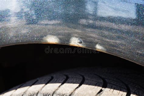 Close Up Of Rust On A Car Wheel Arch Showing Paint And Metal Damage With A Tire At The Bottom
