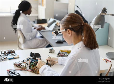 Back View Portrait Of Female Engineer Working With Hardware Parts In Laboratory Copy Space