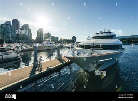 An Impressive Private Yacht Is Moored With Smaller Boats In The Harbour