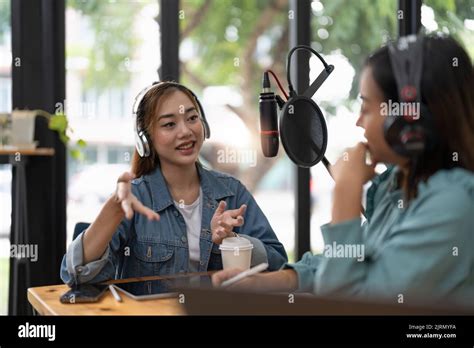 Female Host Recording Radio Podcast Interview With Guest At Home Office