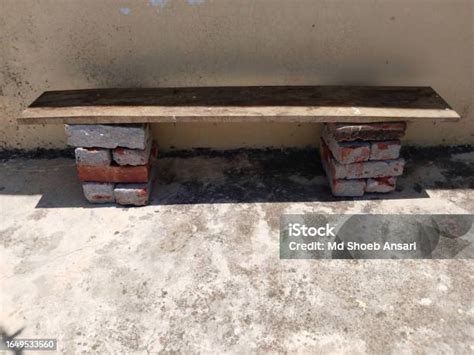 이 판자에 사람들을 앉히기 위해 벽돌에 나무 판자 이러한 유형의 벤치는 농촌 지역의 상점 학교 및 주택에서 사용됩니다 나무 줄기와 널빤지 두 조각으로 만든 나무 벤치 이것은