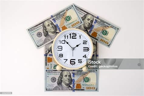 미국 달러 지폐와 고전적인 알람 시계로 집을 만듭니다 시간은 돈 재무 계획 부동산 투자 모기지 마감일 그리고 부를 쌓는 데 있어 시간의 가치입니다 가계에 대한 스톡 사진 및