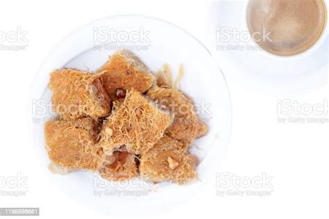 커피 한 잔과 함께 흰색 접시에 갓 만든 아라비아 바클라바를 식욕을 돋우고 있습니다 위에서 볼 수 있습니다 전통 동양 과자 음식 격리된 이미지입니다 텍스트의 장소 갈색에