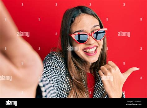 Young Brunette Woman Taking A Selfie Photo Wearing Sunglasses Pointing