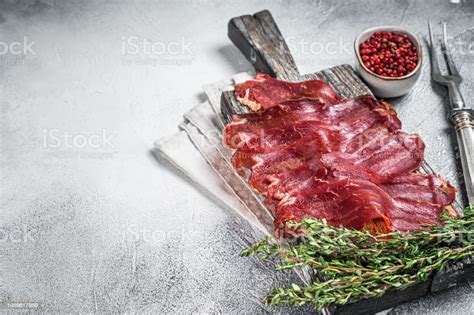 Pastirma 터키어 얇게 썬 파스트 라미 나무 보드에 향신료와 말린 쇠고기 고기 흰색 배경입니다 평면도 복사 공간 할랄에