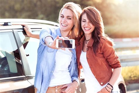 Premium Photo Smiling Girls Taking Selfie With Smart Phone In The City