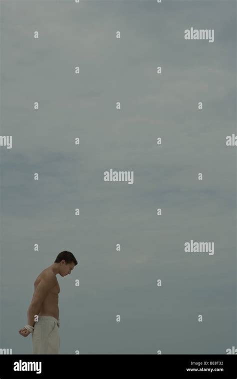 Man Standing Outdoors Hands Tied Behind Back Side View Stock Photo Alamy