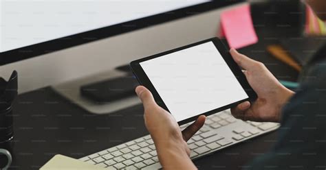 검은색 작업 책상에서 흰색 빈 화면 컴퓨터 모니터 앞에 흰색 빈 화면 컴퓨터 태블릿을 들고 있는 똑똑한 남자 손의 자른 이미지 사진 Unsplash의 컴퓨터 키보드 이미지