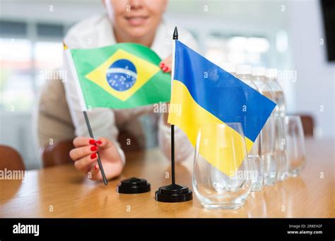 Unrecognizable Girl Sets Midget Flags Of Ukraine And Brazil Before International Negotiations