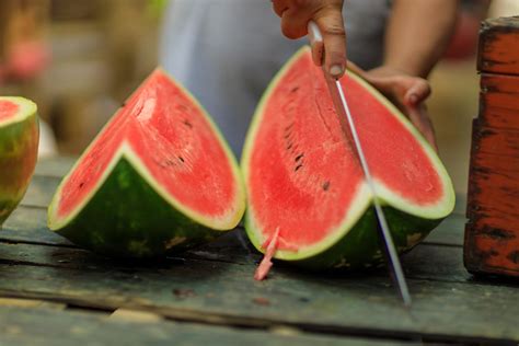 야외에서 신선한 수박 조각을 자르는 모습 · 무료 스톡 사진