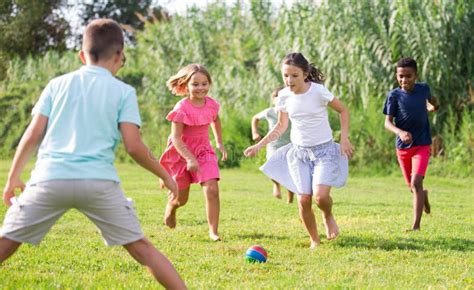 Cheerful Tween Friends Playing With Ball Outdoors In Summer Stock Image