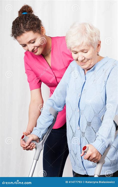 De Verpleegster Helpt Om De Oude Vrouw Te Lopen Stock Afbeelding Image Of Pensionering
