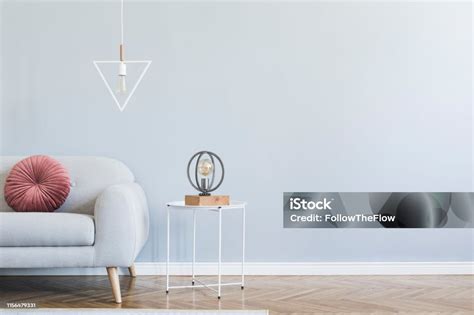 디자인 회색 소파 커피 테이블 램프 베개와 열린 공간의 미니멀하고 세련된 인테리어 회색 배경 벽 갈색 나무 마루 객실의 현대적인