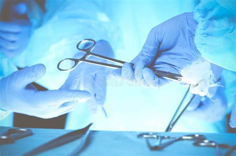 Surgeons Hands Holding Surgical Scissors And Passing Surgical Equipment Close Up Health Care