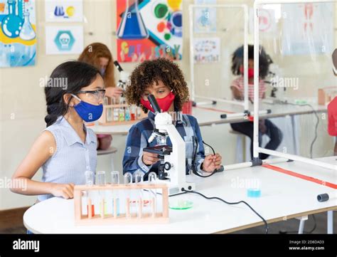 Babe And Girl Wearing Face Mask Using Microscope In Laboratory Stock Photo Alamy