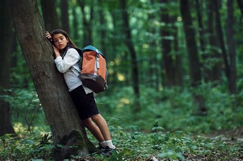 Premium Photo Leaning On The Tree Girl Is In The Forest At Summer Day Time Discovering New Places