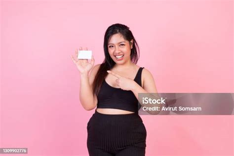 흰색 카드를 가리키는 뚱뚱한 여성 분홍색 배경에 서 행복 과체중 여자 뚱뚱한 뚱뚱한 여자 플러스 크기 패션 모델 핑크 배경에