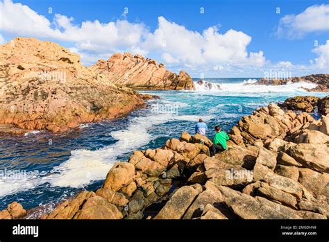 People Watching The Tidal Surge Of Water Through The Narrow Granite