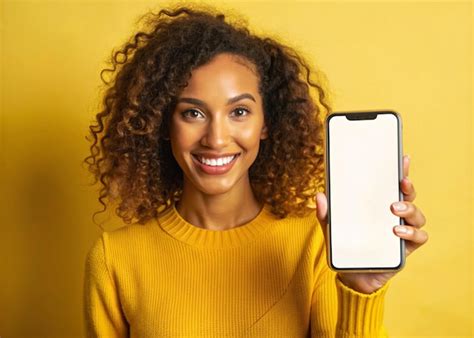 A Young Woman Is Holding A Mobile Phone And Showing A Blank White