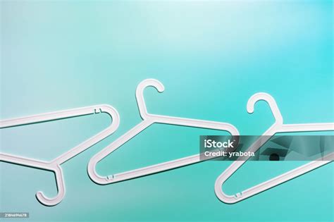 청록색 톤의 부드러운 그라디언트 배경에 최소한의 레이아웃으로 흰색 플라스틱 옷걸이를 설정 옷장이나 소매점에서 옷을 정리하기위한 옷걸이 옷걸이 평면도 0명에 대한 스톡 사진