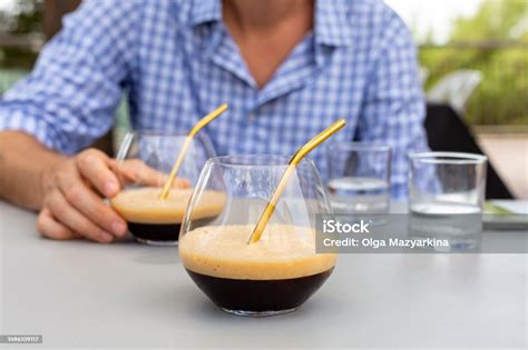 금속 빨대로 카페 셰이크라토를 마시는 남자 칵테일 셰이커에 에스프레소와 얼음 조각을 사용하여 준비한 이탈리아 차가운 음료 이탈리아 여름 커피 음료 이탈리아 커피 마실 것에