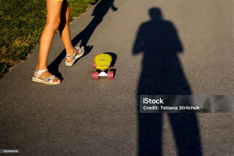 공원에서 길에 페니 스케이트 보드와 작은 아이를 디포커스 소년과 소녀는 햇빛의 날에 페니 보드를 타고 화창한 여름 날에 야외 라이프 스타일 사진 긴 그림자 활동적인 취미