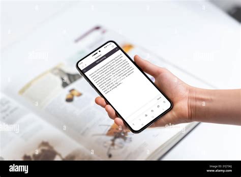hand holding smartphone scanning text in book representing technology
