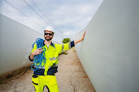 오후에 건설 현장에서 대형 풍력 터빈 블레이드 사이에 서 있는 안전 장비를 착용한 작업자가 건설 산업에 대한 스톡 사진 및 기타 이미지 건설 산업 건설 현장 계획