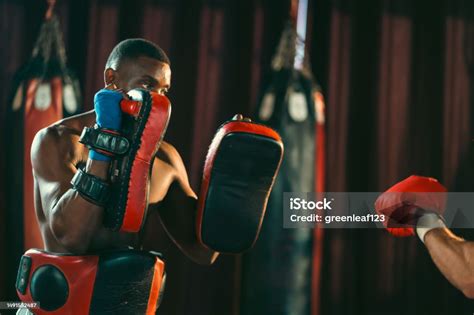 개인 트레이너와 스파링 패드로 스포츠 체육관에서 복싱의 피트니스 훈련과 싸우십시오 건강 동기 부여 및 근육 운동 펀치를 던지는 권투 선수 Mma 스튜디오에서 스포츠 장갑을