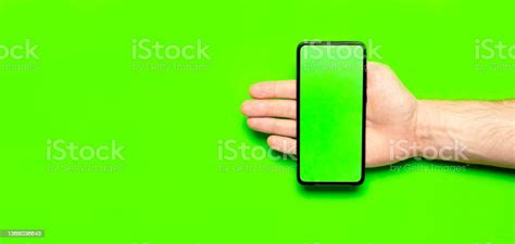 남성 핸즈는 네온 그린 배경 평면 평지 상단보기에 녹색 빈 화면과 현대적인 검은 색 스마트 폰을 개최합니다 현대 기술 전화 손에 가제트 터치 스크린 디자인템플릿 모형