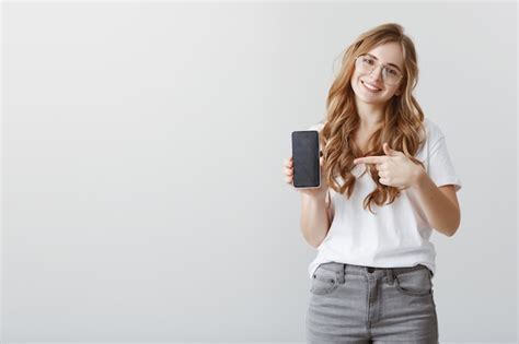 Free Photo Smiling Attractive Blond Girl In Glasses Pointing Finger