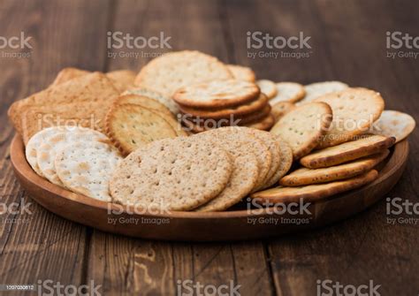 나무 배경에 둥근 접시에 참깨와 소금을 곁들인 다양한 유기농 바삭한 밀 호밀 및 옥수수 플랫 브레드 크래커 0명에 대한 스톡 사진 및 기타 이미지 Istock