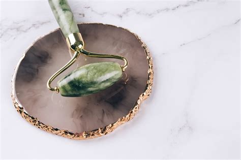 흰색 대리석 테이블 배경에 비취 얼굴 롤러와 구아 샤 도구의 가까이보기 천연 돌로 만든 리프팅 마사지 요법을 위한 페이셜 마사지 키트 퍼스널 스킨 케어 안티 에이징 도구 0