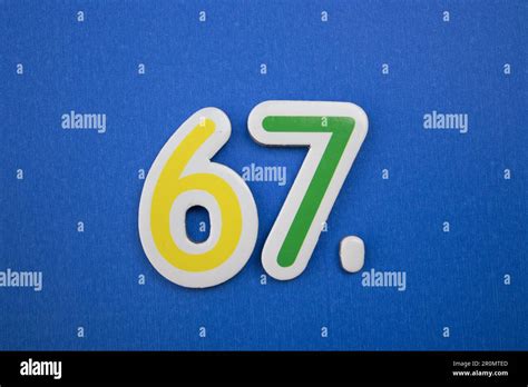 The Number 67 Placed On A Blue Background Photographed From Above