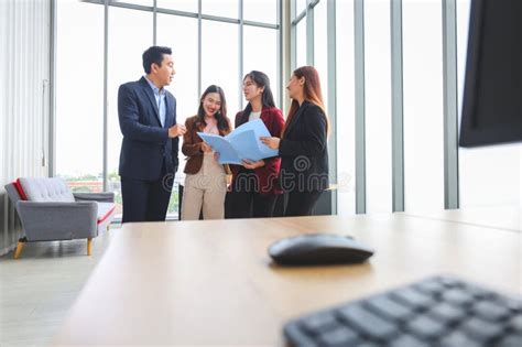 Asian Business Colleagues Brainstorming Together At Work Startup Team Planning And Discussing