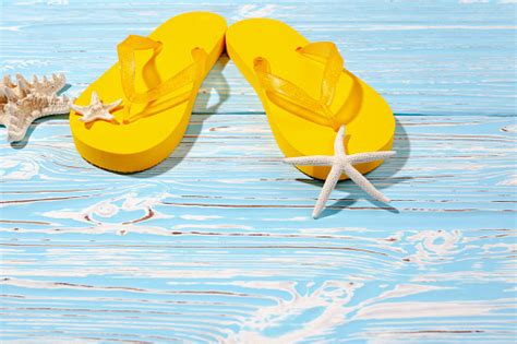 노란색 고무 해변 플립 플롭과 파란색 나무 배경에 불가사리 텍스트 아래에 배치 0명에 대한 스톡 사진 및 기타 이미지 0명 경관 계절 Istock