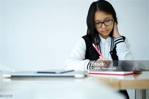 대학 노트에 메모를 작성에 초점을 맞추고 중국 젊은 재능 있는 학교 소녀 사려깊은 아시아 학생 커피가 게에 나무 책상에 앉아