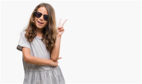 갈색 머리 히스패닉 여자 선글라스 승리 표시를 하 고 카메라에 윙크 하는 행복 한 얼굴로 미소를 착용 번호 2입니다 T 셔츠에 대한 스톡 사진 및 기타 이미지 Istock