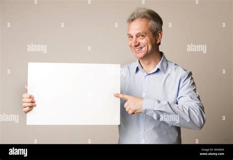 Mature Man Holding Blank Board And Pointing On It Stock Photo Alamy