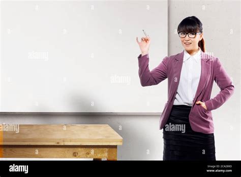 Asian Teacher Woman With Marker Standing In The Classroom With Whiteboard Background Back To