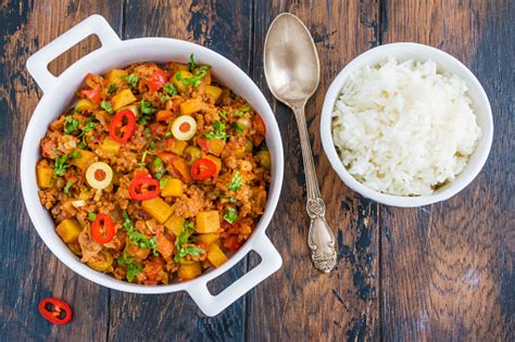 고전적인 쿠바 접시 Picadillo 갈은 쇠고기와 토마토 건포도와 흰색 캐 서 롤 및 나무 시골풍 테이블에 삶은 쌀에 올리브의 부드러운 향기로운 스튜 보기 가기 쿠바에